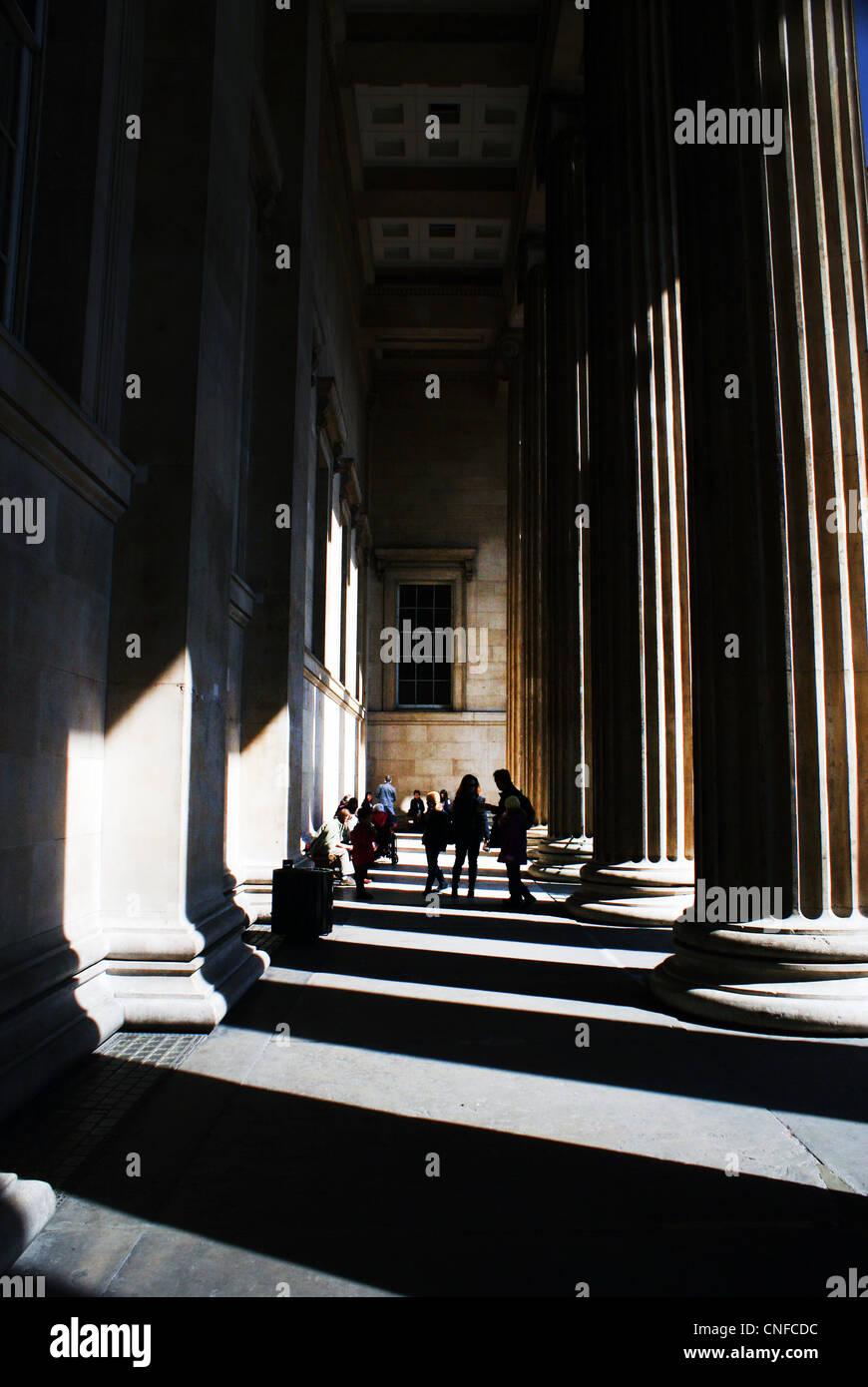People walking around large columns Stock Photo - Alamy