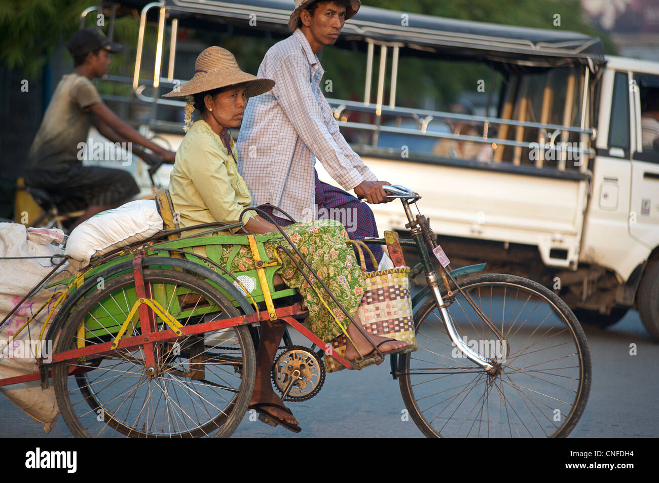 Burmese urban street scene - woman and produce being transported in a ...