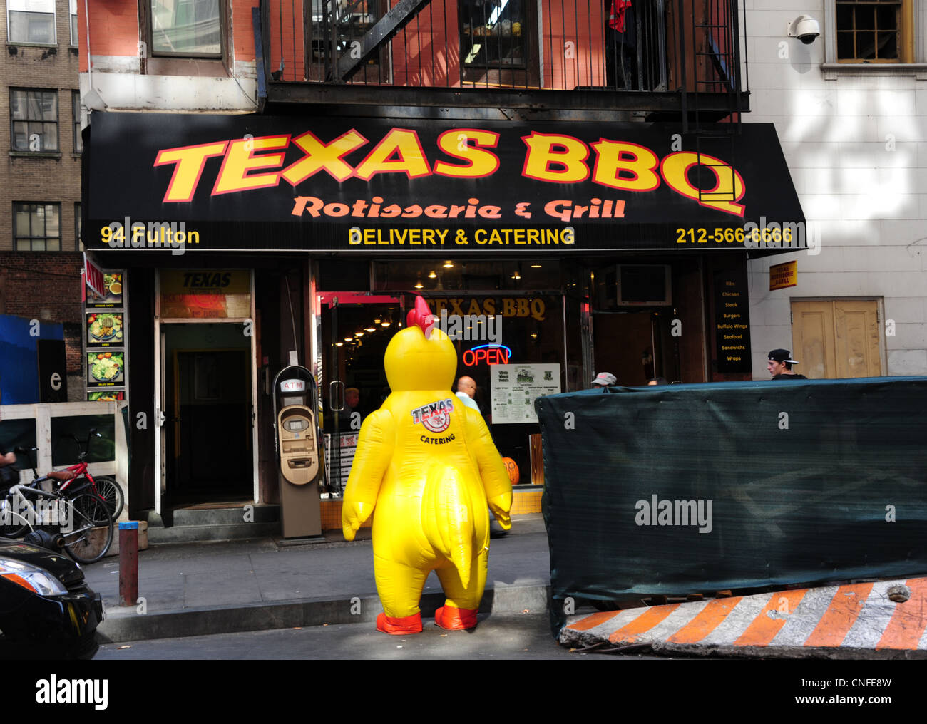 Large yellow blow-up chicken standing in front of Texas BBQ Rotisserie ...