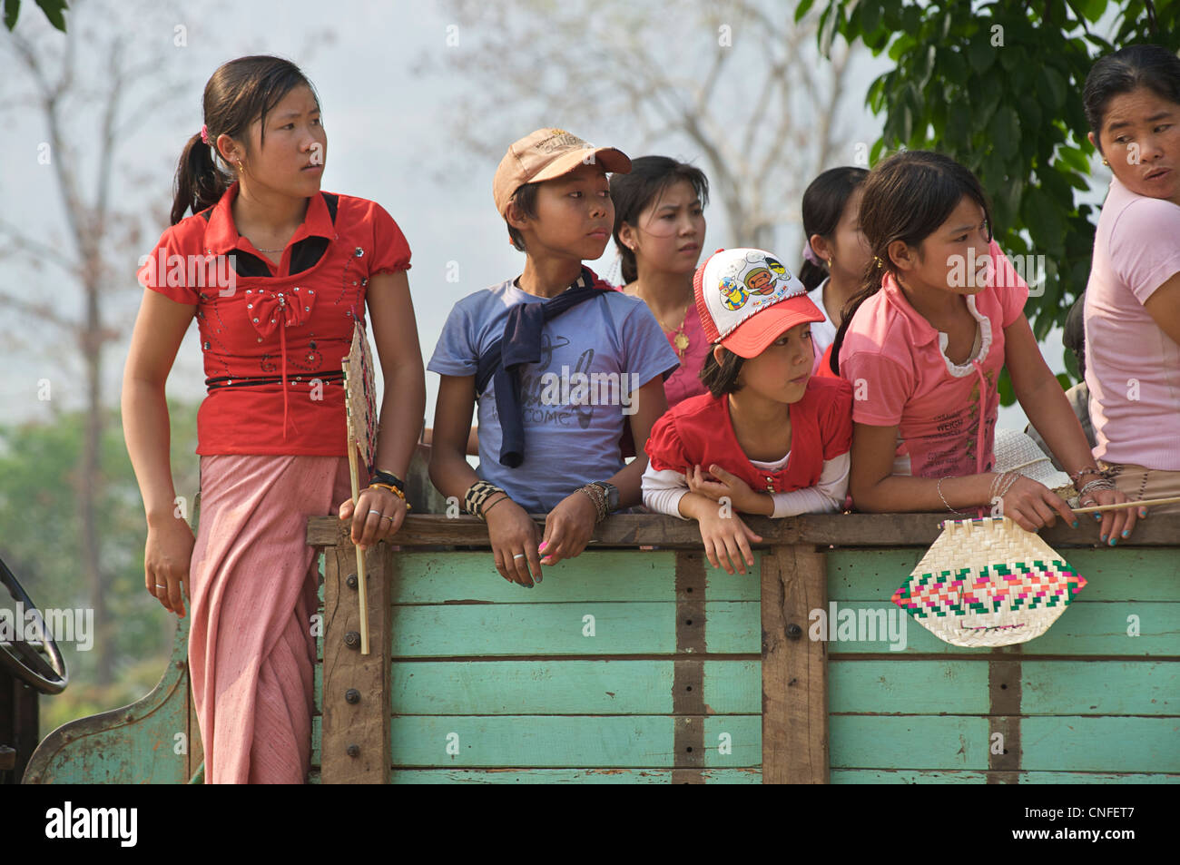 Burmese villagers travelling to a festival in the back of a truck. Near ...