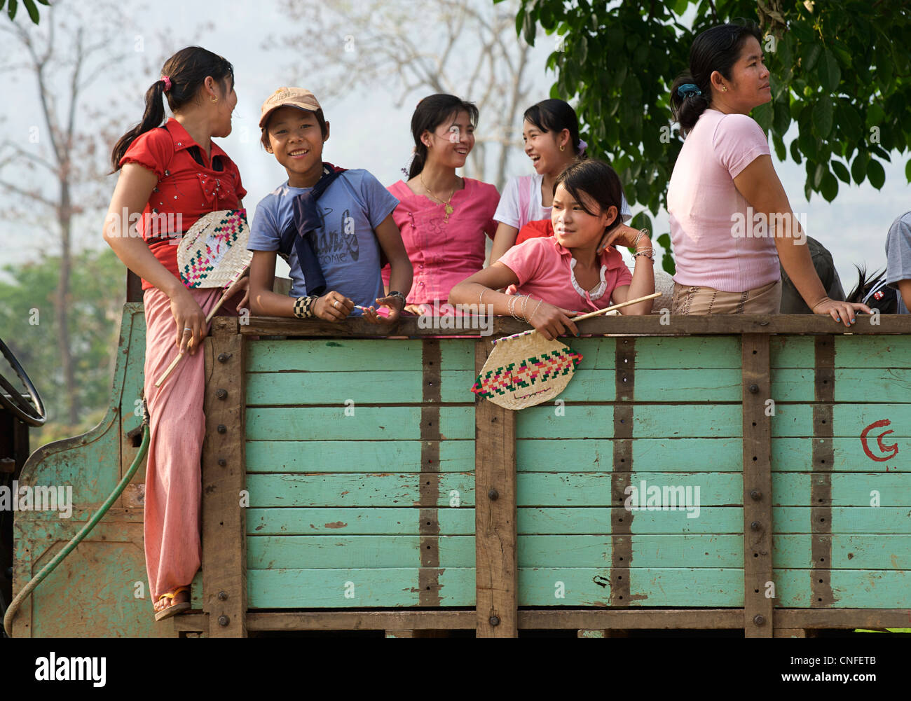Burmese villagers travelling to a festival in the back of a truck. Near ...