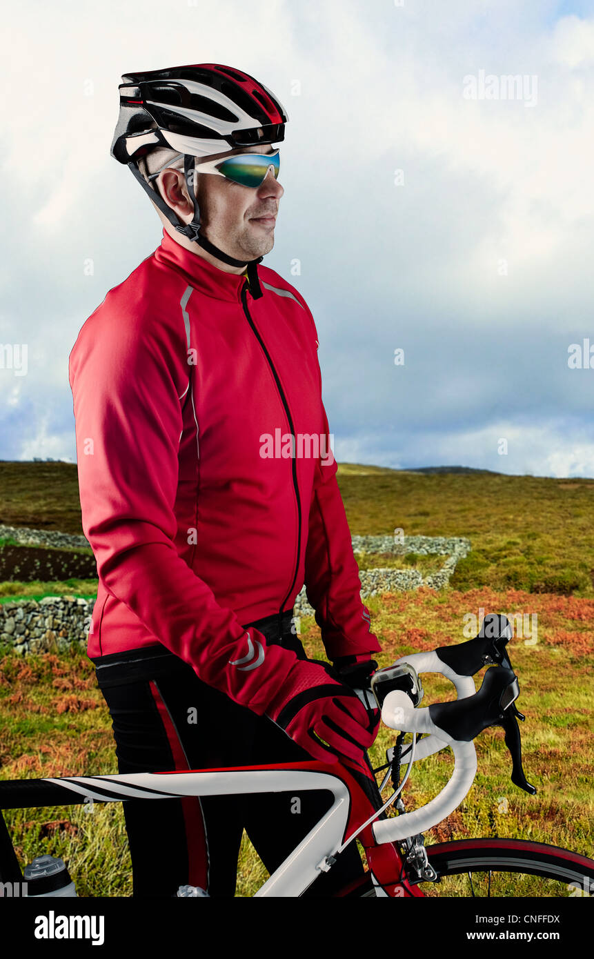 Cyclist standing and looking to a beautiful green landscape with his ...
