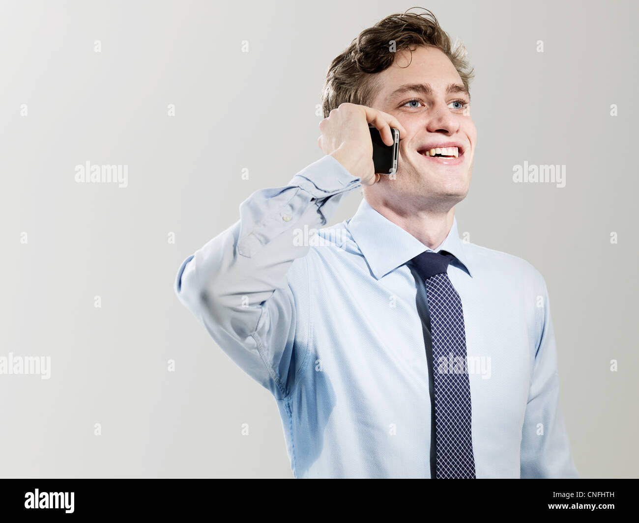 Young businessman sweating and using cellphone, studio shot Stock Photo ...
