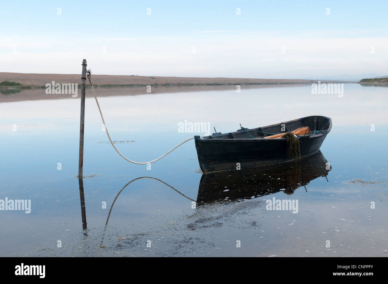 Moored wooden rowing boat on still water Stock Photo - Alamy