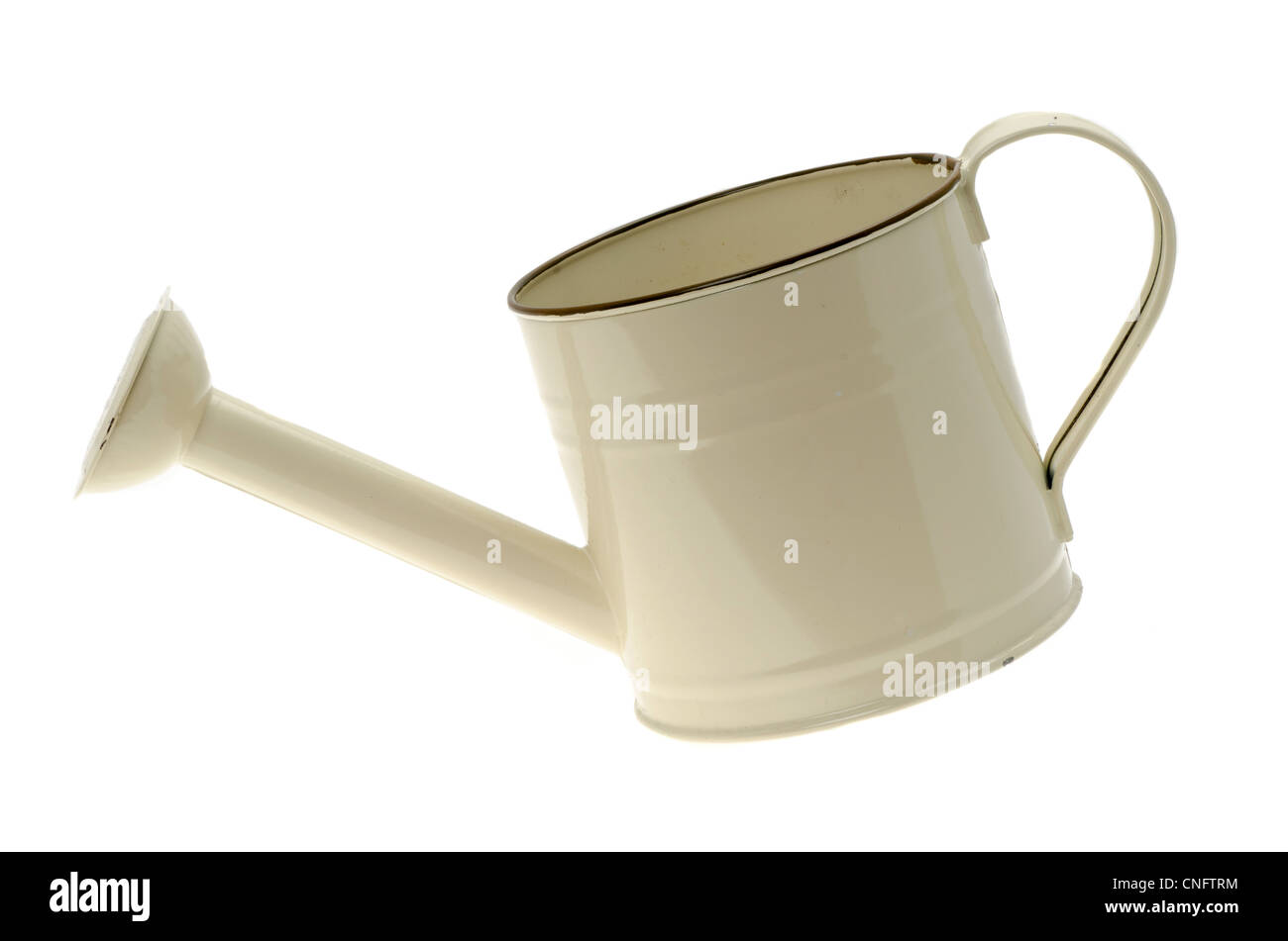 Tilted cream coloured metal watering can isolated on a white background ...