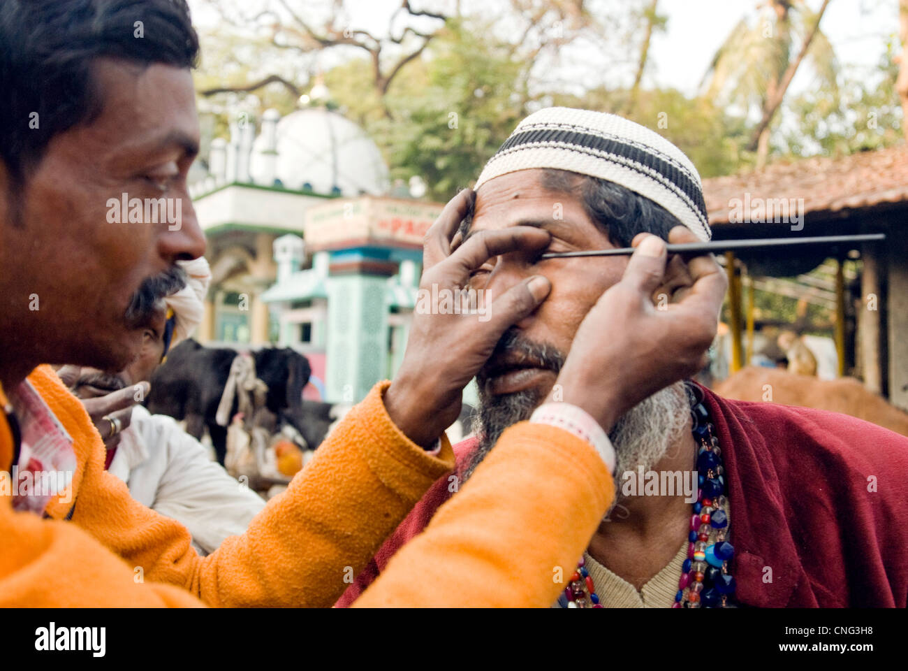 Muslim man coloring eyes ,Pagla Baba shrine ,Kolkata Stock Photo - Alamy