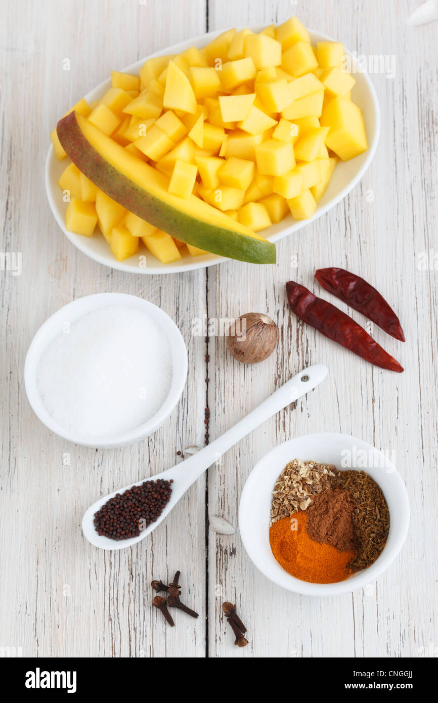 A collection of ingredients like mango slices, sugar and several spices ...