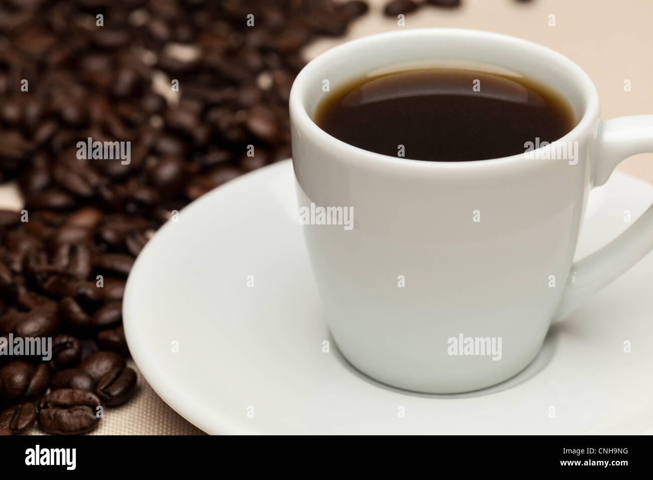 A cup of coffee in front of coffee beans background Stock Photo - Alamy