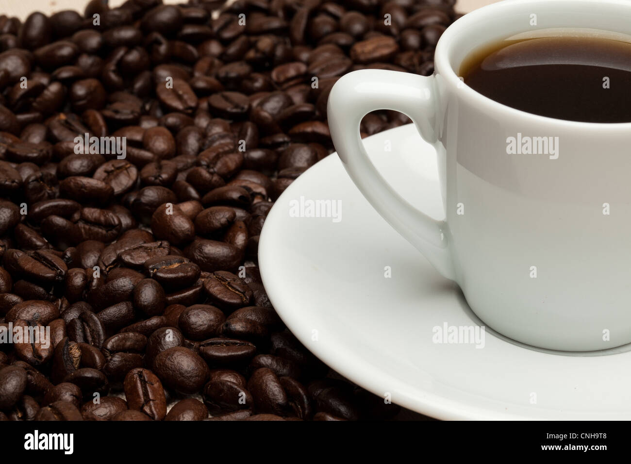 A cup of coffee in front of coffee beans background Stock Photo - Alamy