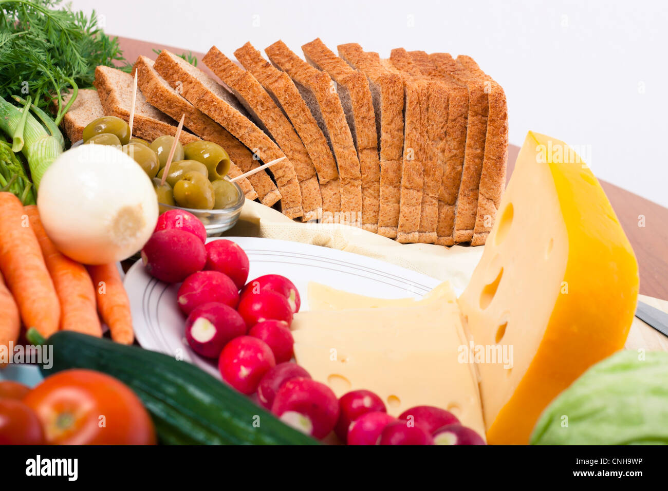 Detail of table with cheese, bread and vegetable Stock Photo - Alamy