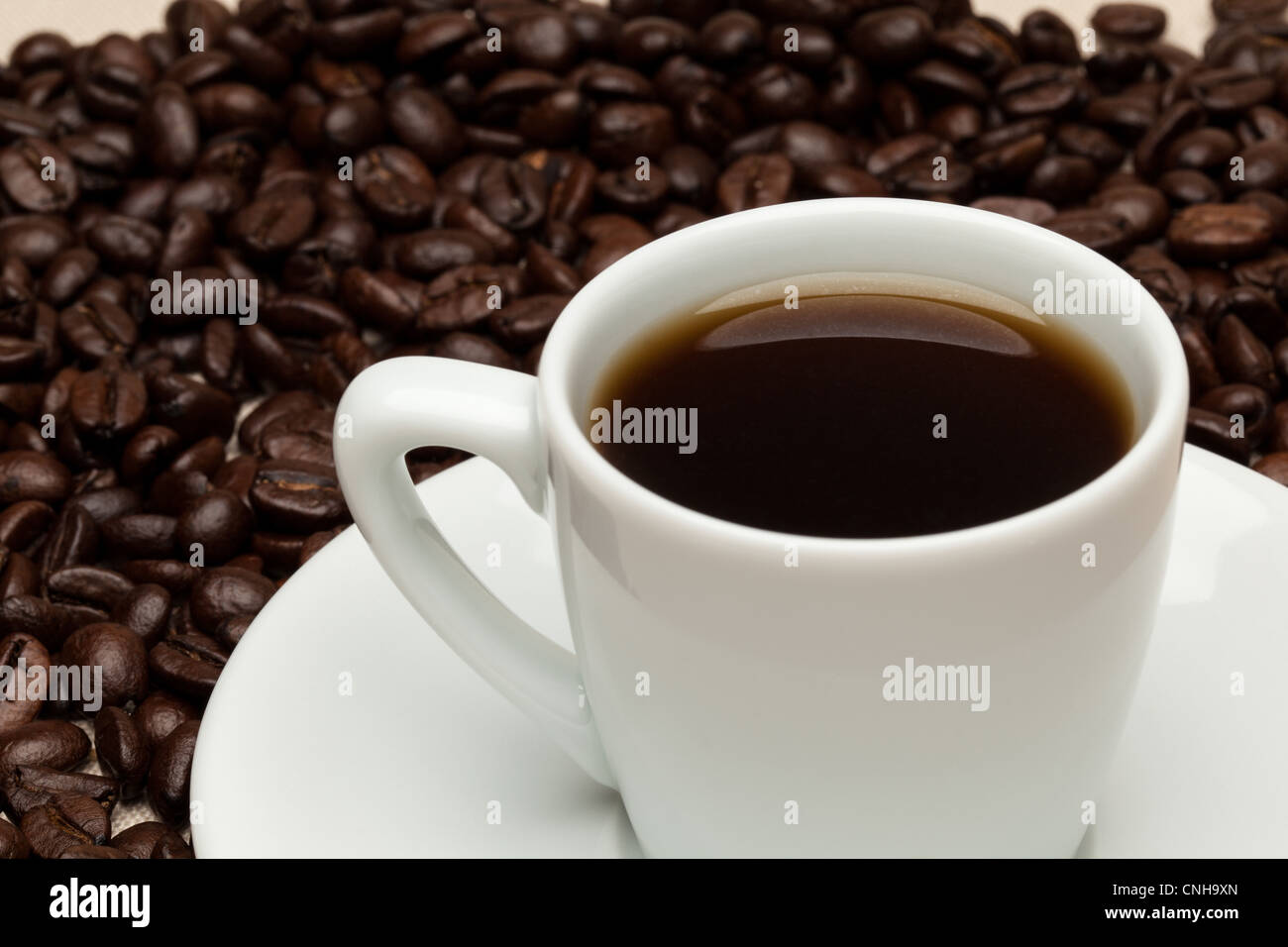 A cup of coffee in front of coffee beans background Stock Photo - Alamy