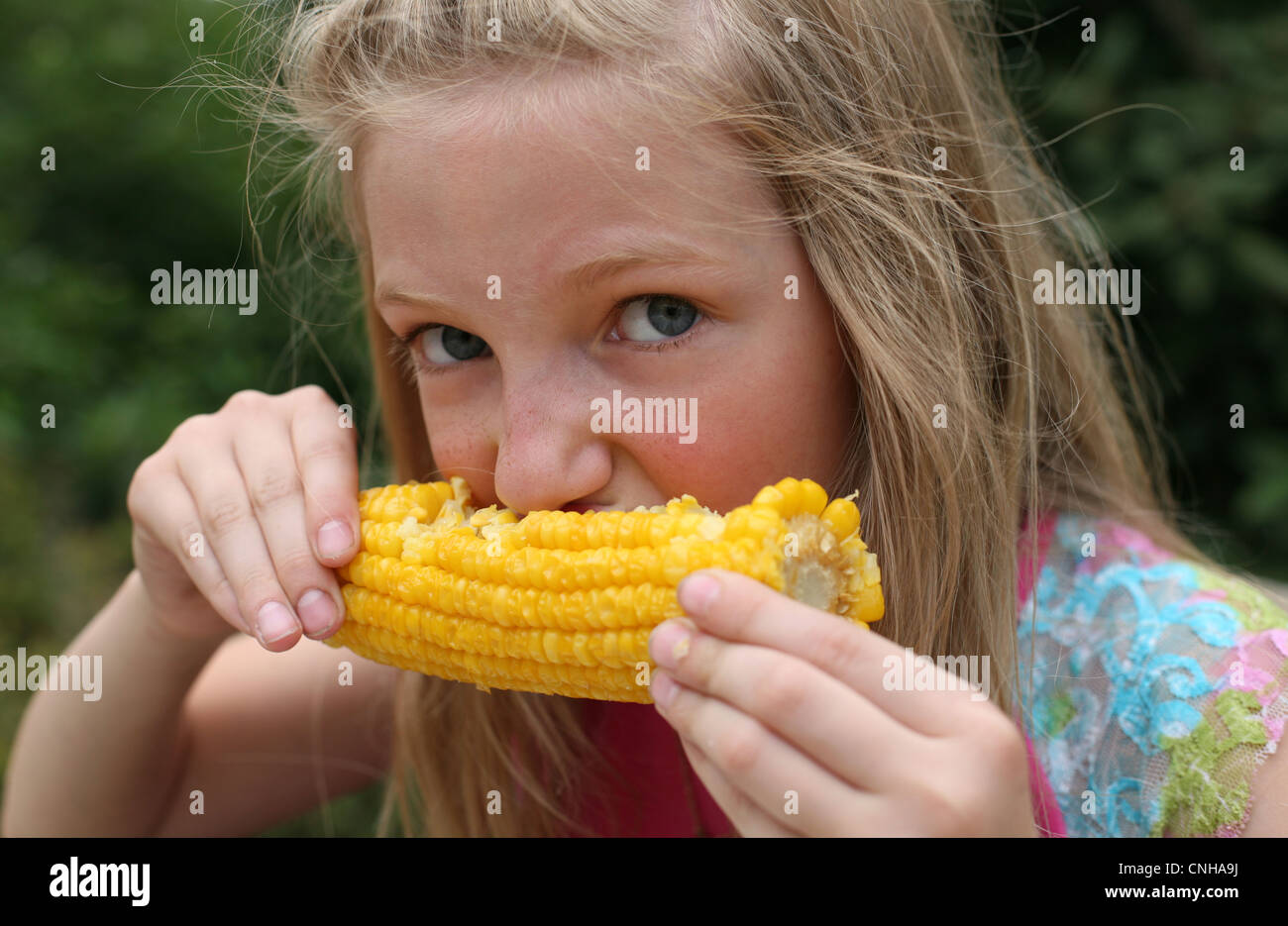 Young girl eating a boiled corn Stock Photo - Alamy