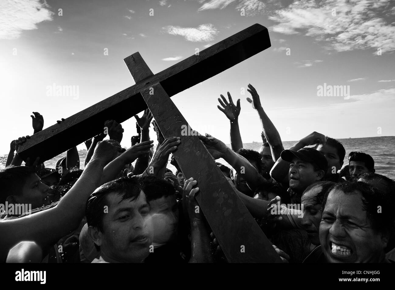 Catholic followers carry the wooden cross in the sea during the annual ...