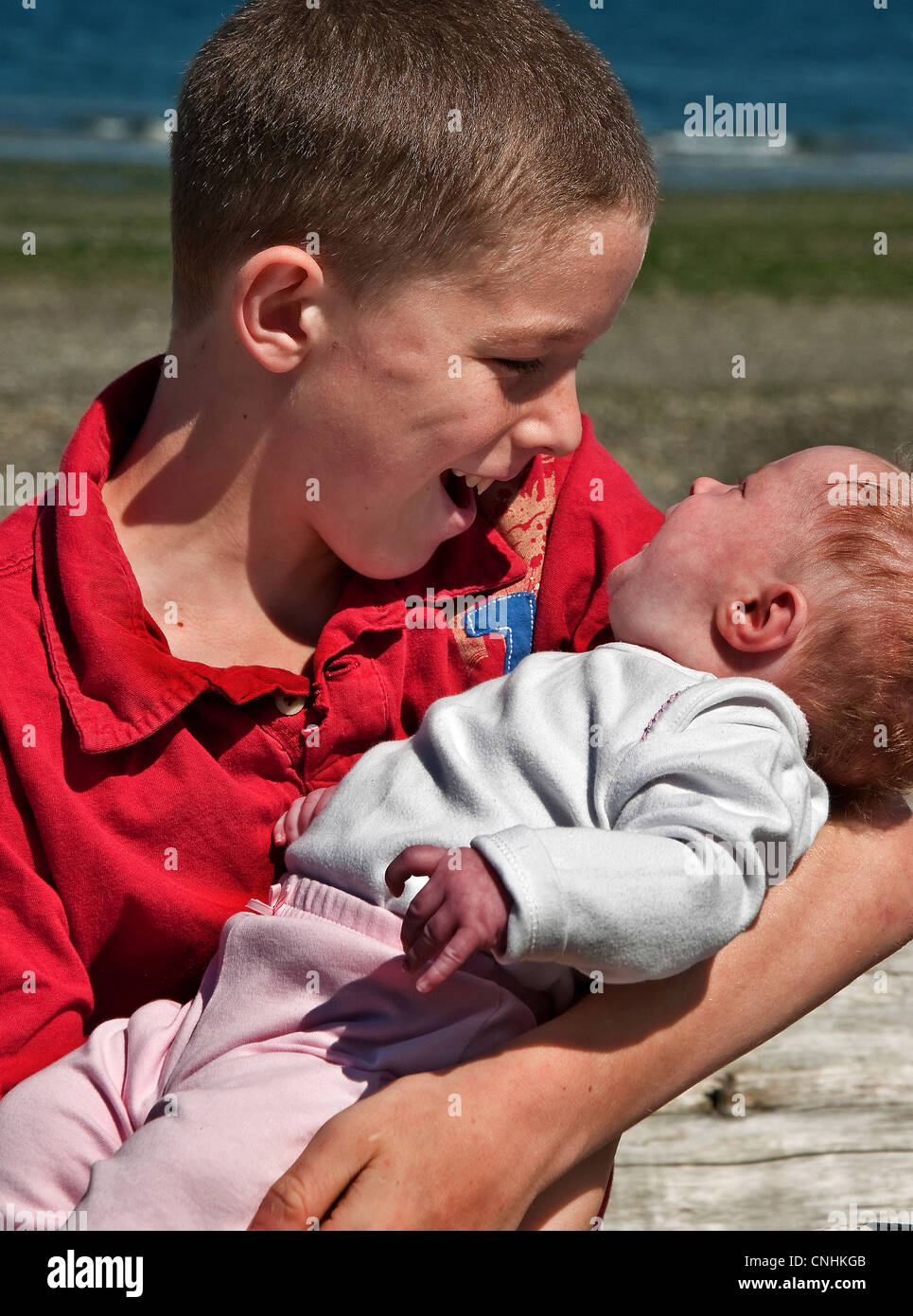 loving big brother holding and interacting with his newborn baby sister ...
