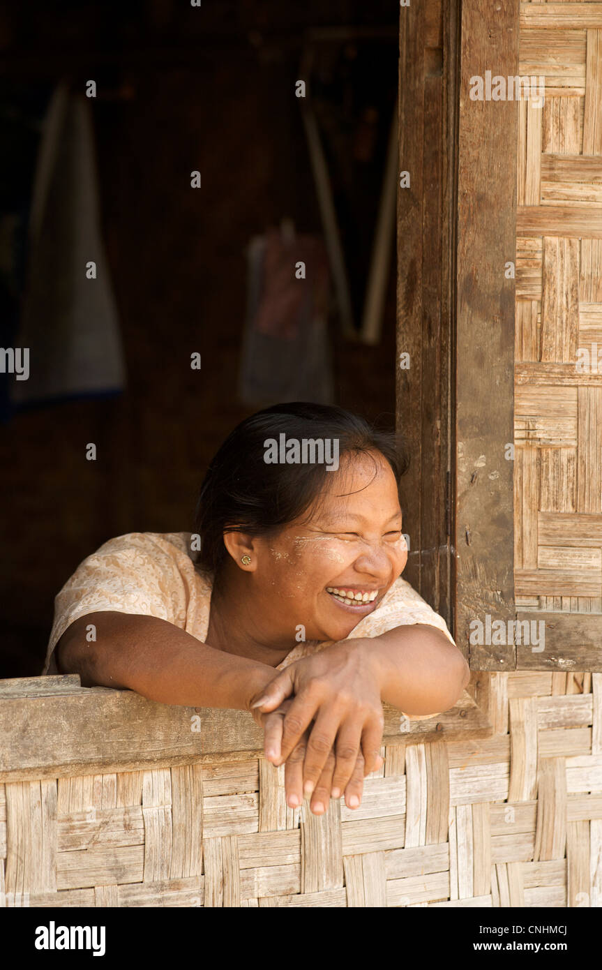 Burmese woman in the window of her home. Near Monywa, Sagaing Region ...