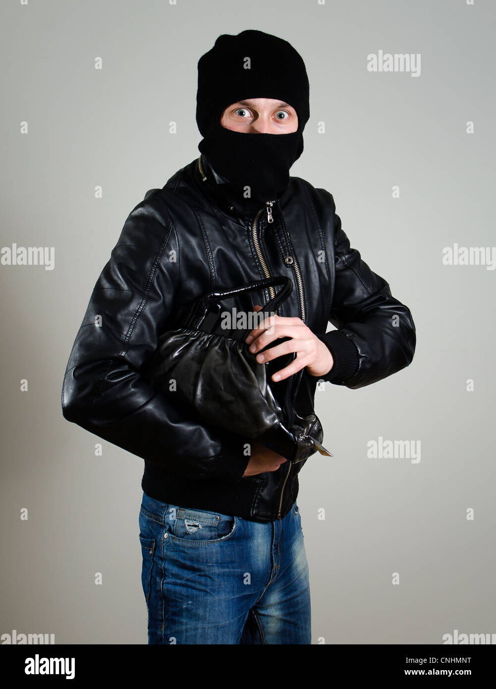 Portrait of scared male burglar with a handbag Stock Photo - Alamy