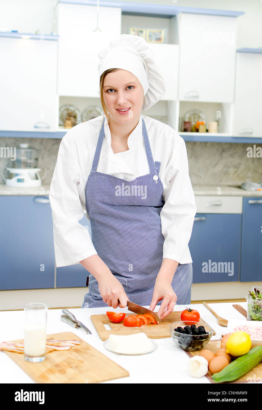 Attractive chief cook preparing food, cutting tomatoes Stock Photo - Alamy