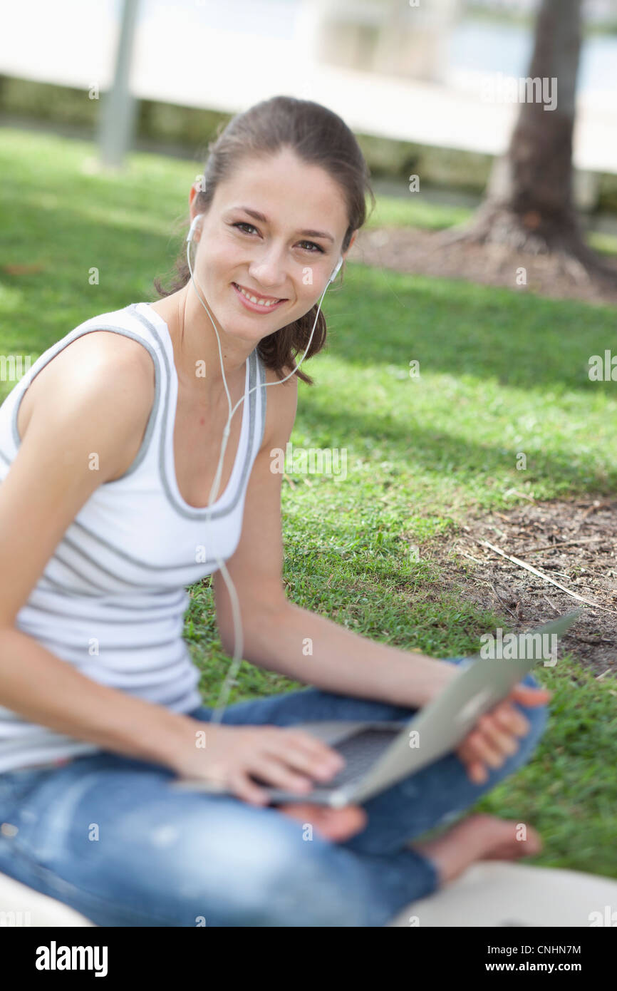 Happy girl using laptop outside Stock Photo - Alamy