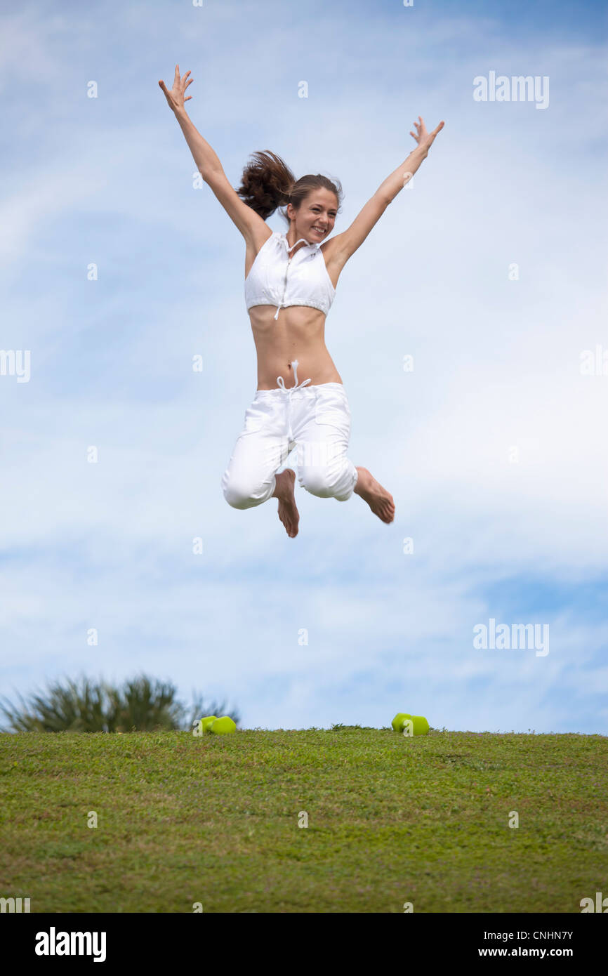 Girl jumping in mid-air in field Stock Photo - Alamy