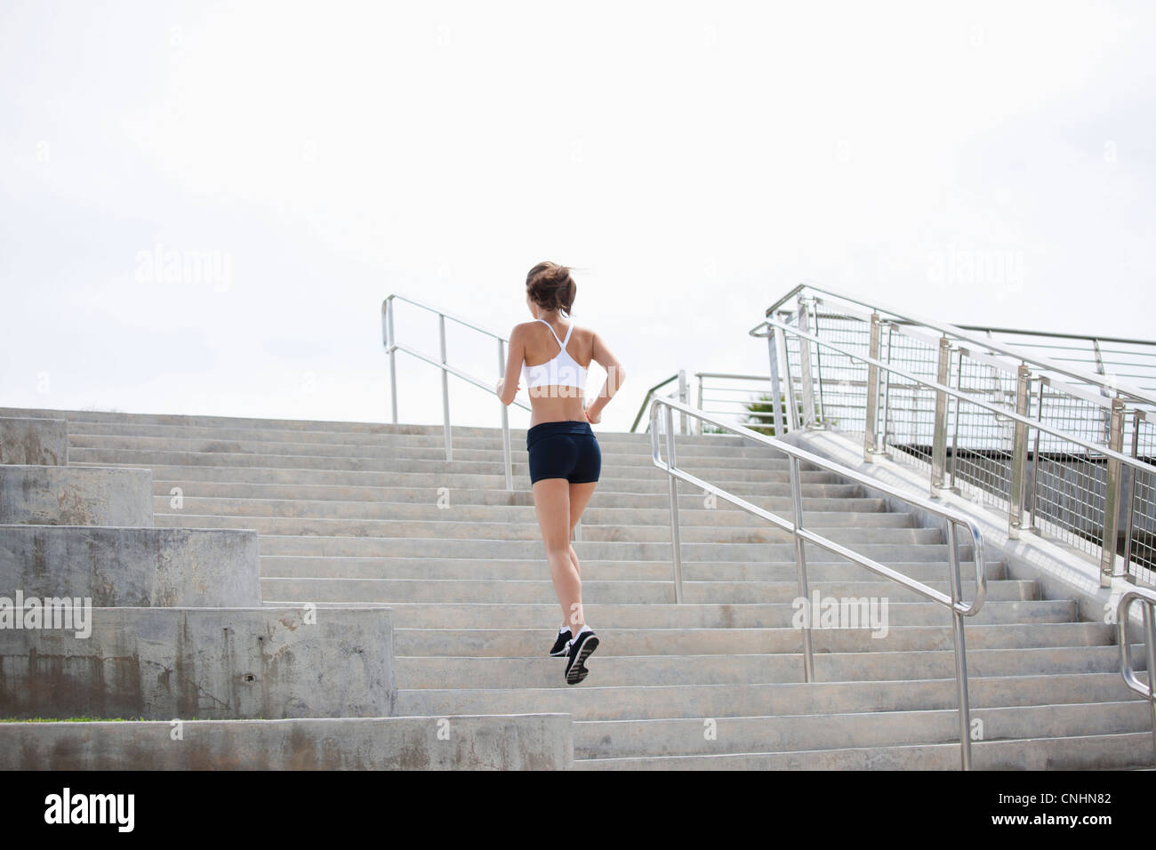 Girl jogging up steps Stock Photo - Alamy