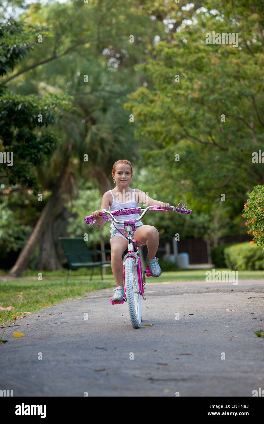 Girl riding bike through park Stock Photo - Alamy