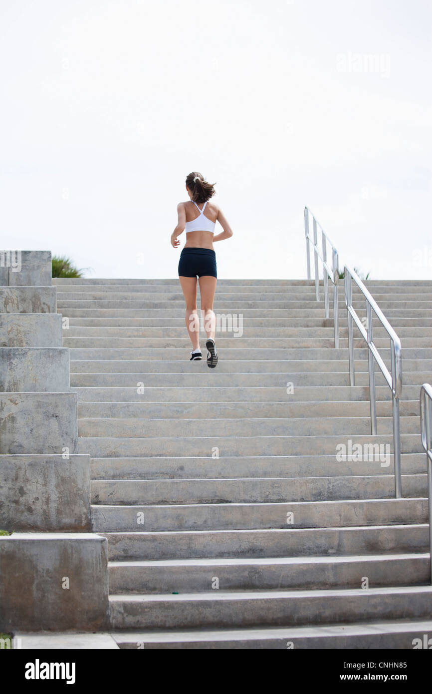 Girl jogging up steps Stock Photo - Alamy