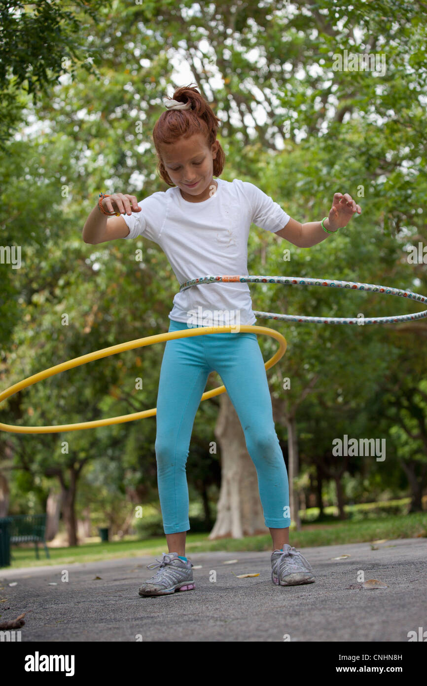 Girl with hula hoops in park Stock Photo - Alamy