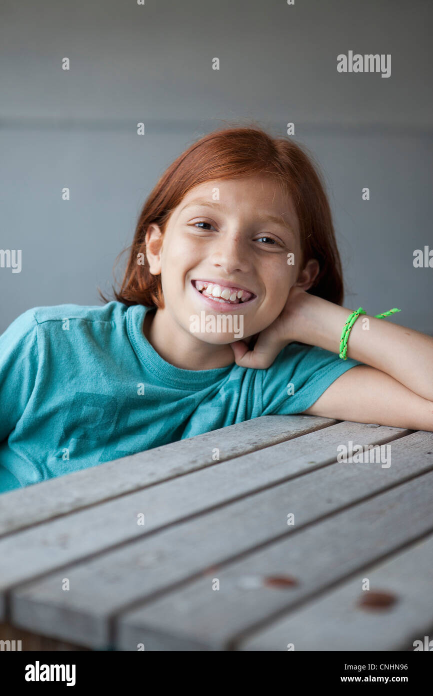Portrait of young girl leaning against table Stock Photo - Alamy