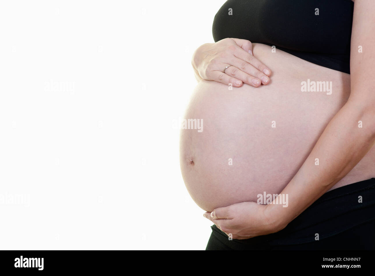 A pregnant woman holding her belly, midsection, side view Stock Photo ...