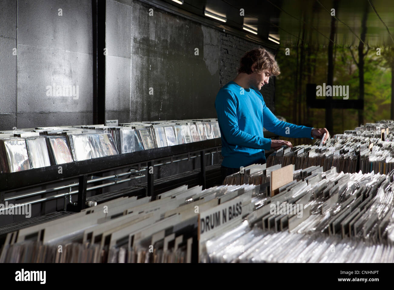 A young man searching through records in a record store Stock Photo - Alamy