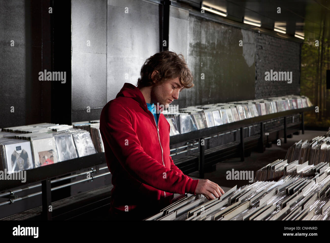 A young man looking through records at a record store Stock Photo - Alamy