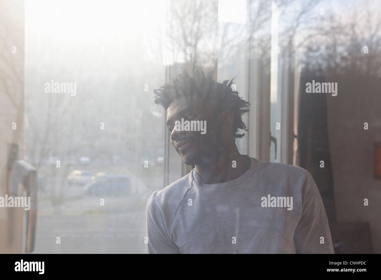 A young man looking out of a window Stock Photo - Alamy