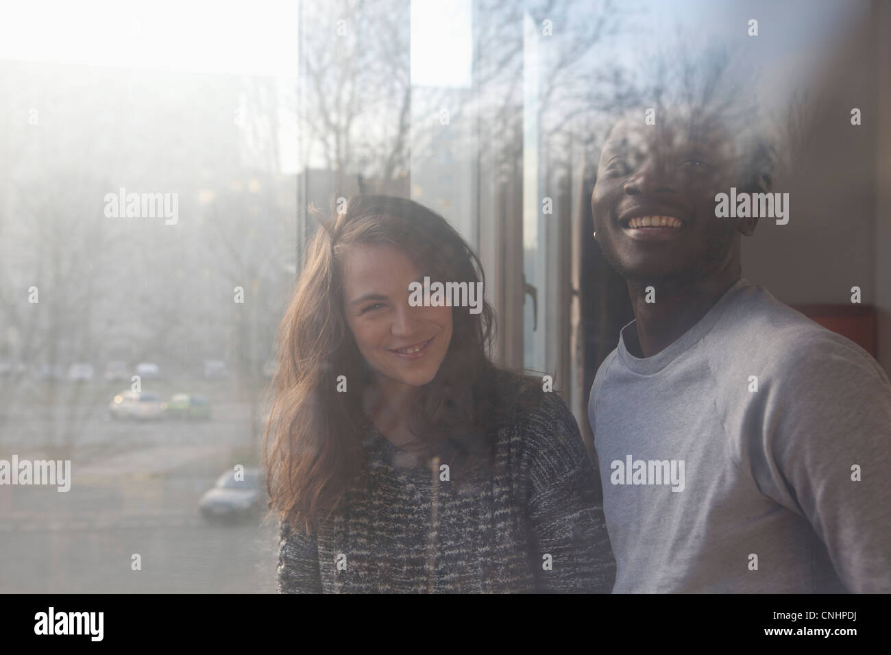 A boyfriend and girlfriend laughing together, viewed through window ...