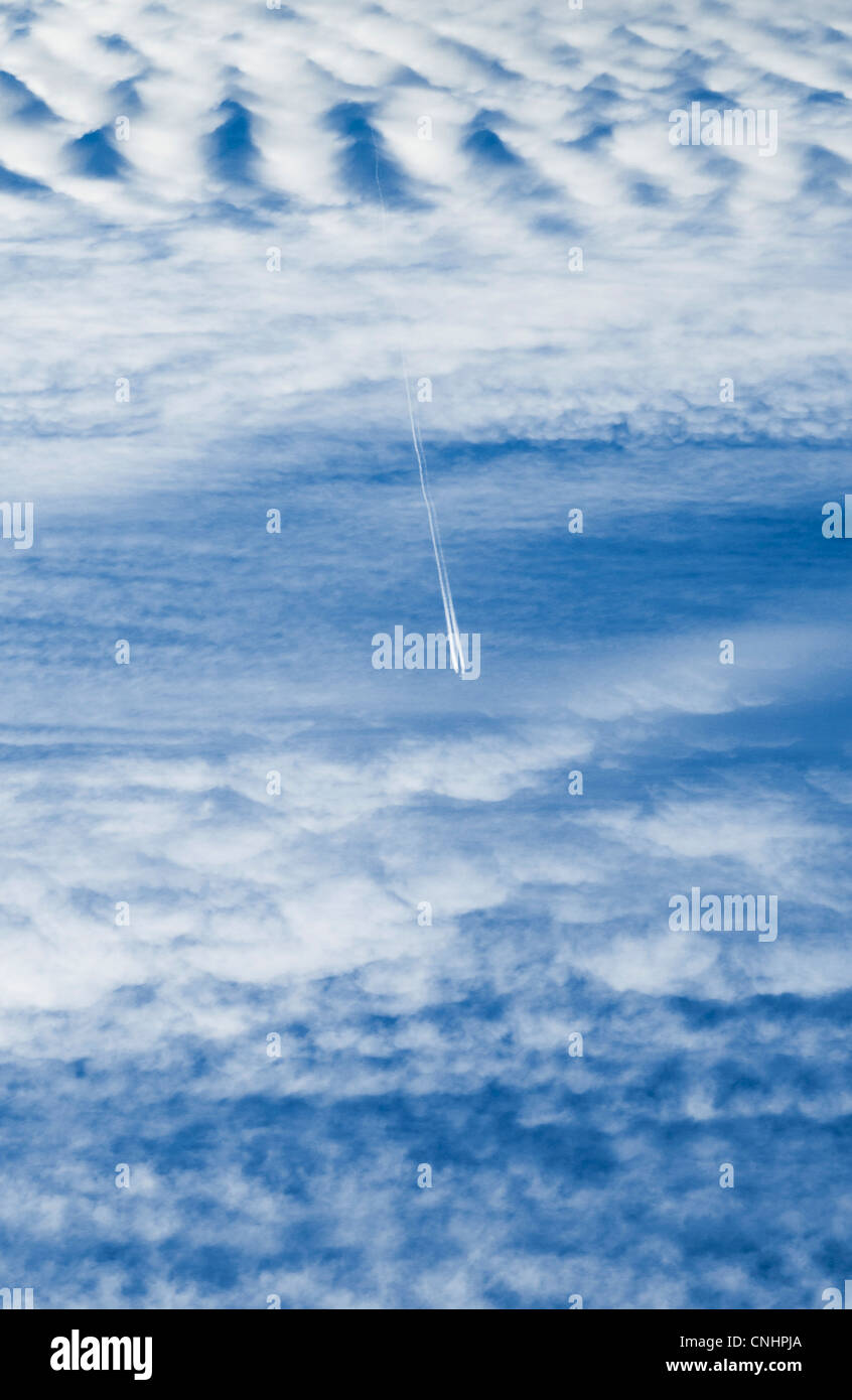 Plane vapor trail over cloudscape Stock Photo - Alamy