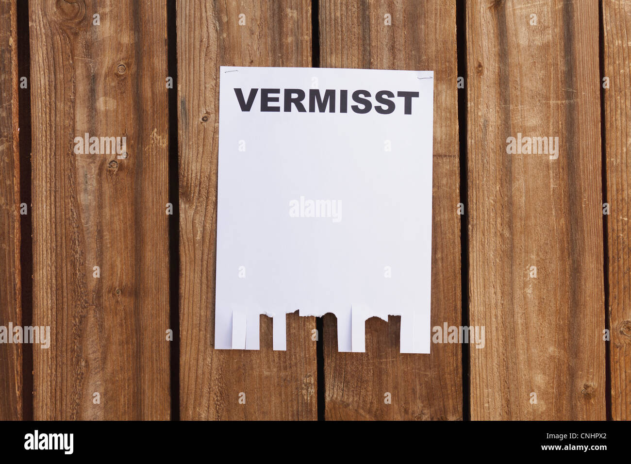 A flyer posted on a wooden fence with the German word for missing on it ...