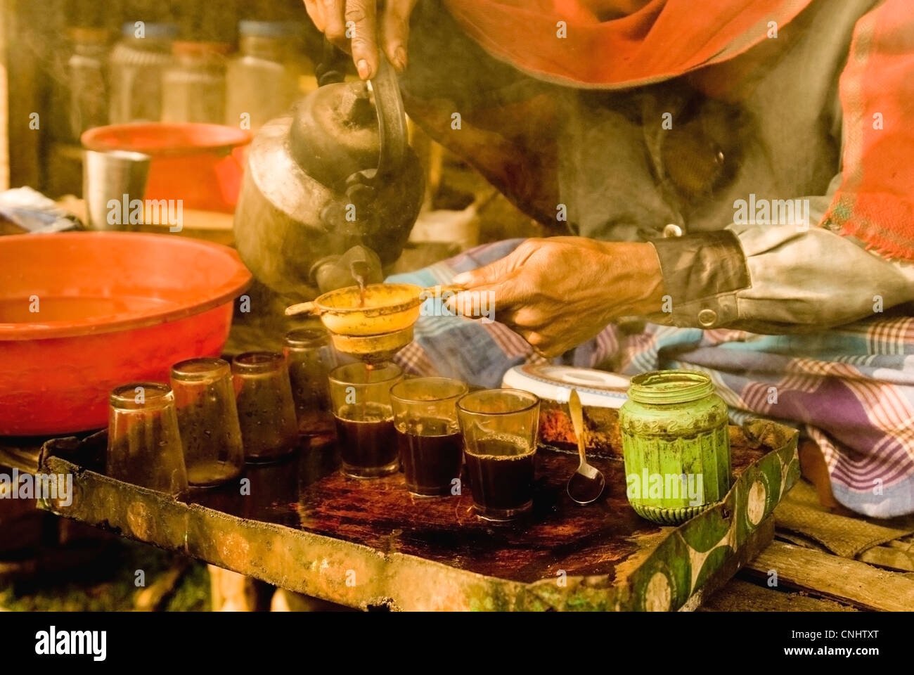 Man preparing black tea in the small tea stall in Bagerhat, Bangladesh ...