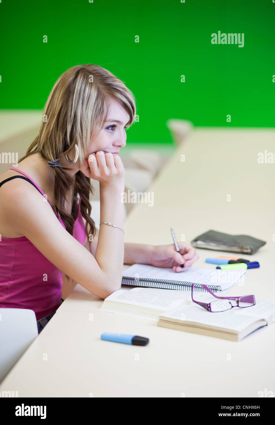 Portrait of a pretty young college student in a classroom (selective ...
