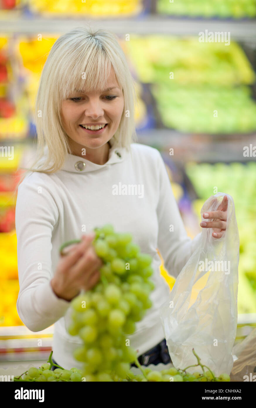 Beautiful young woman shopping for fruits and vegetables in produce ...