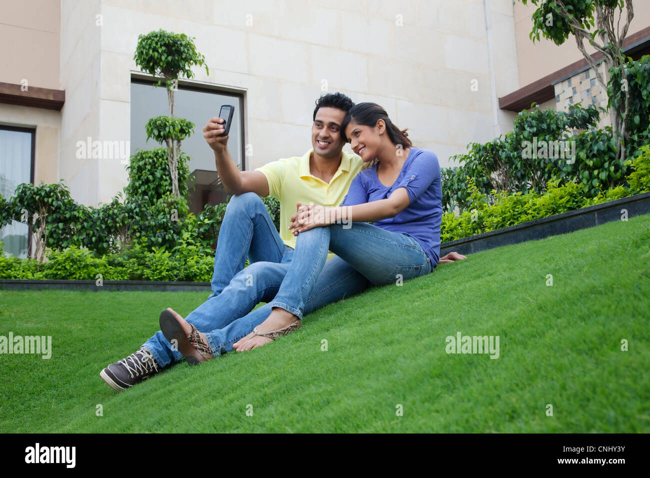 Couple taking a self portrait on a lawn Stock Photo - Alamy