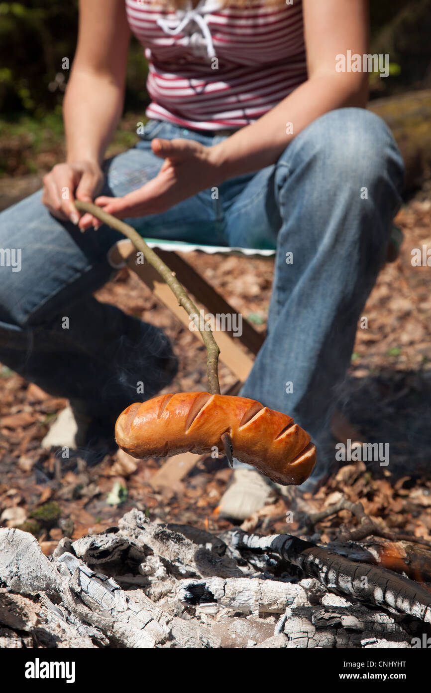Sausage roasting on fire, outdoor activity, barbecue Stock Photo - Alamy