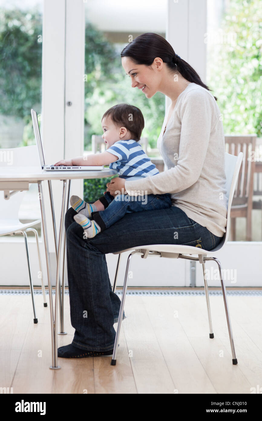 Young woman and baby son using laptop Stock Photo - Alamy