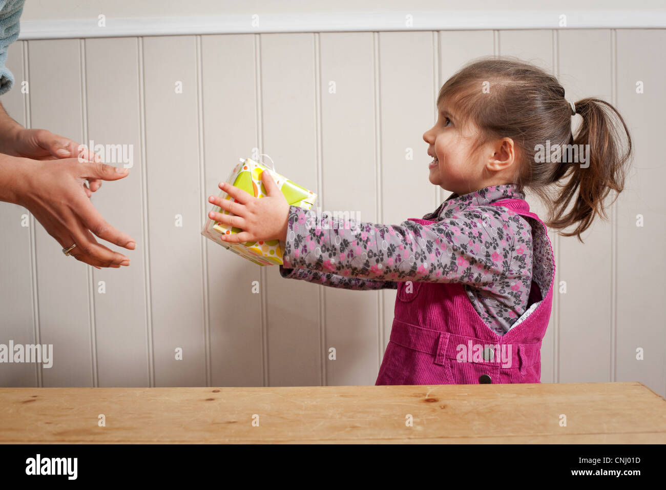 Little girl giving a gift to adult Stock Photo - Alamy