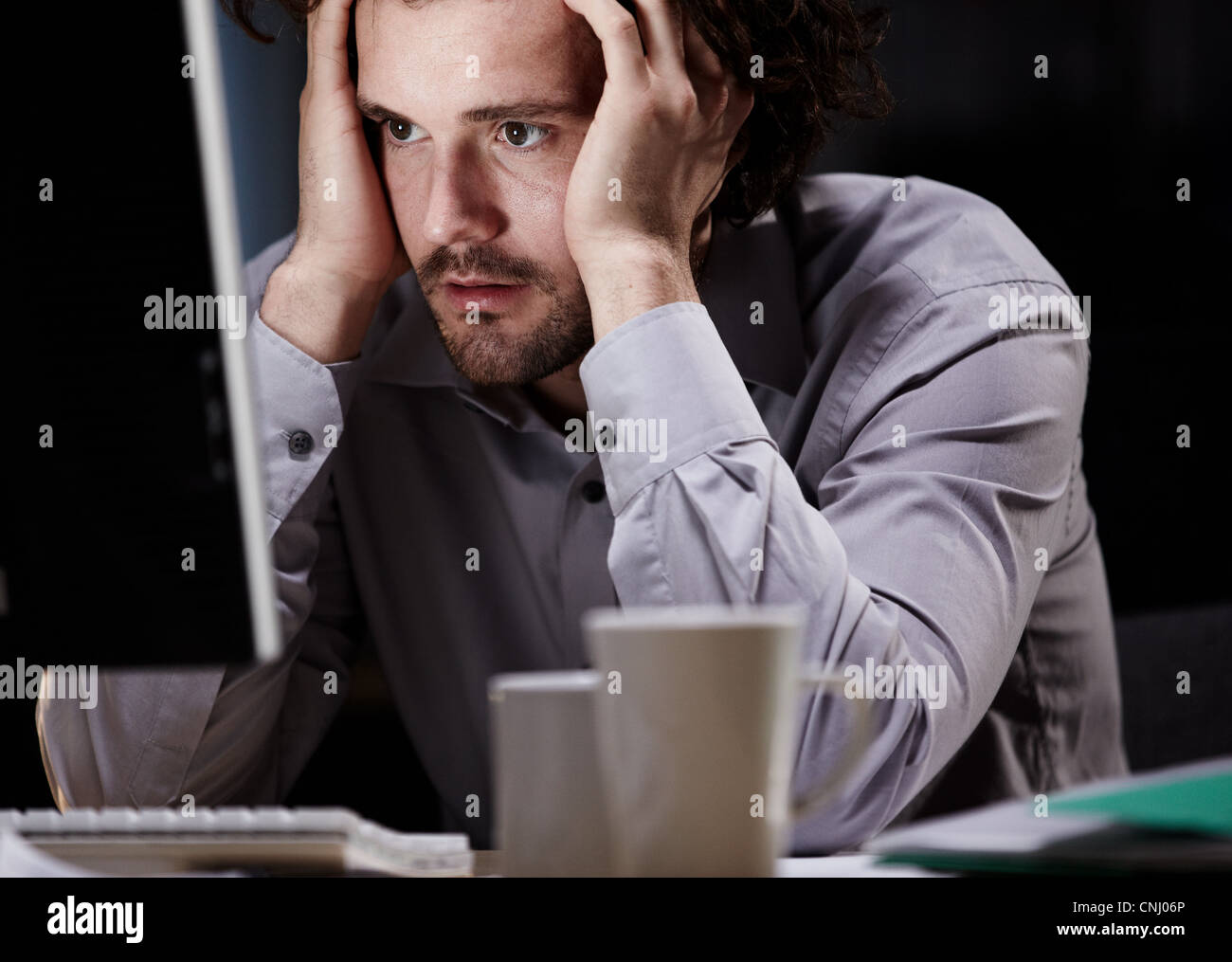 Stressed young man, working late Stock Photo - Alamy