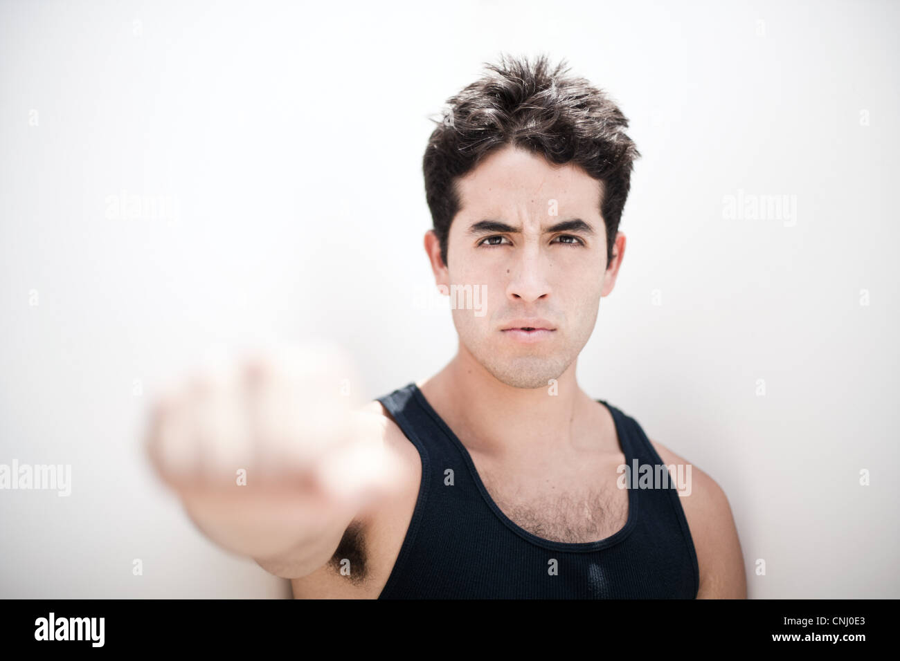 Young man holding fist out towards camera, focus on background Stock ...