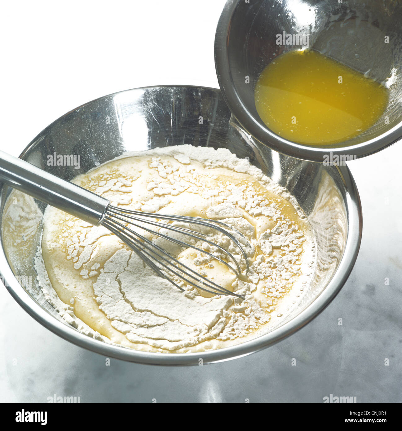 Adding melted butter to the flour Stock Photo - Alamy