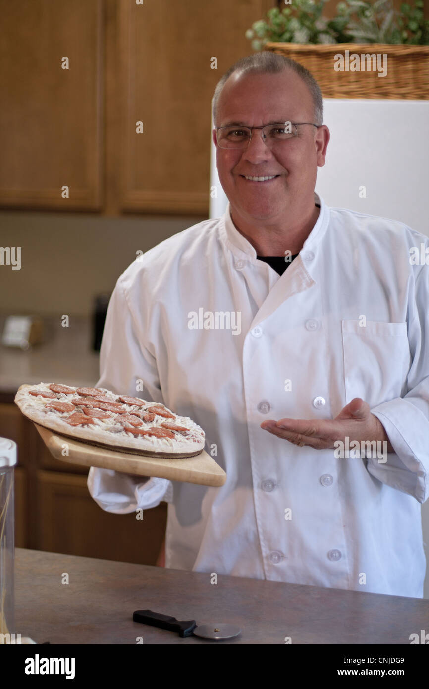 chef with frozen pizza in kitchen presenting Stock Photo - Alamy