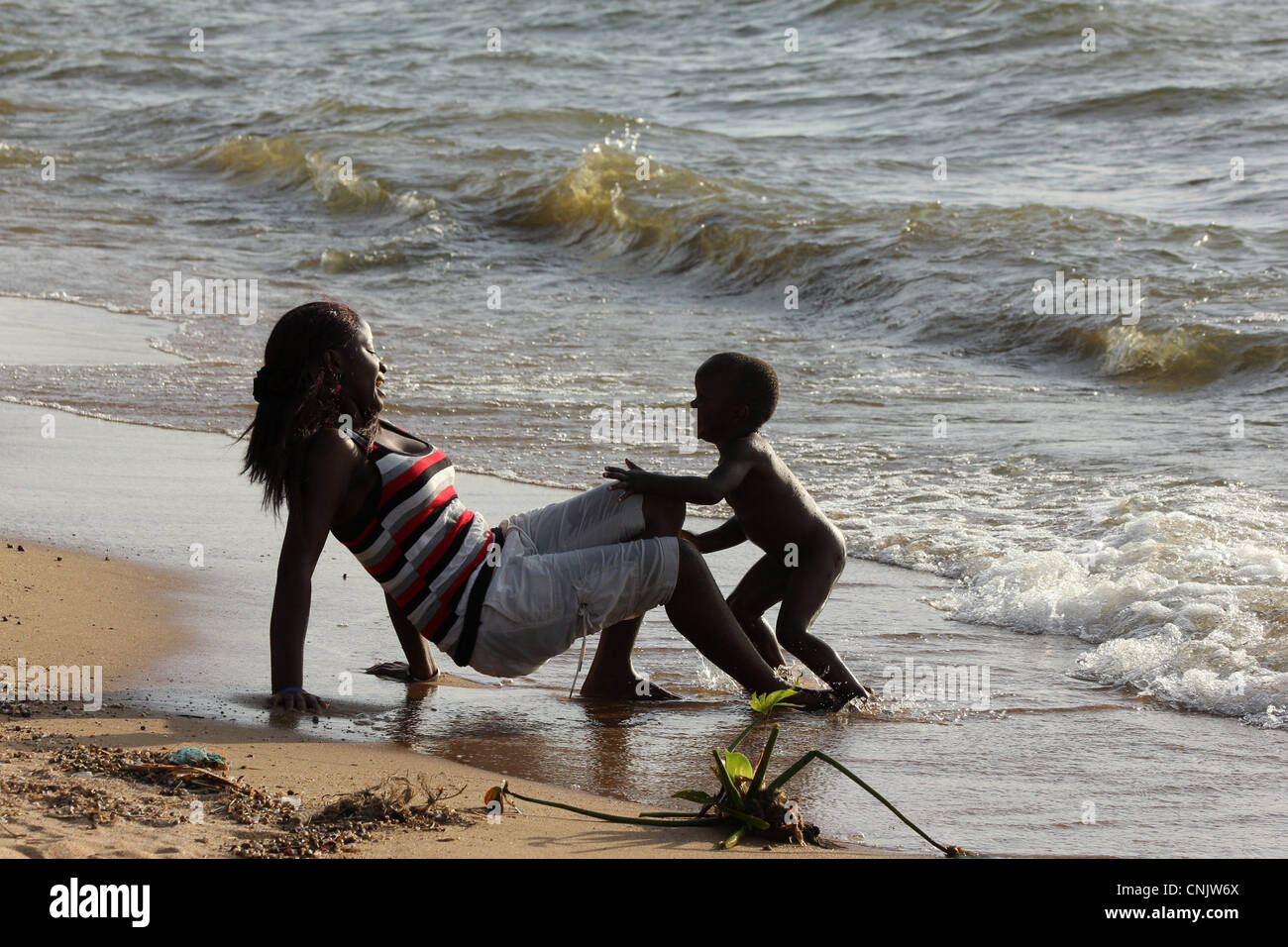 Mother with child playing at the shore of Victoria lake, Musoma ...