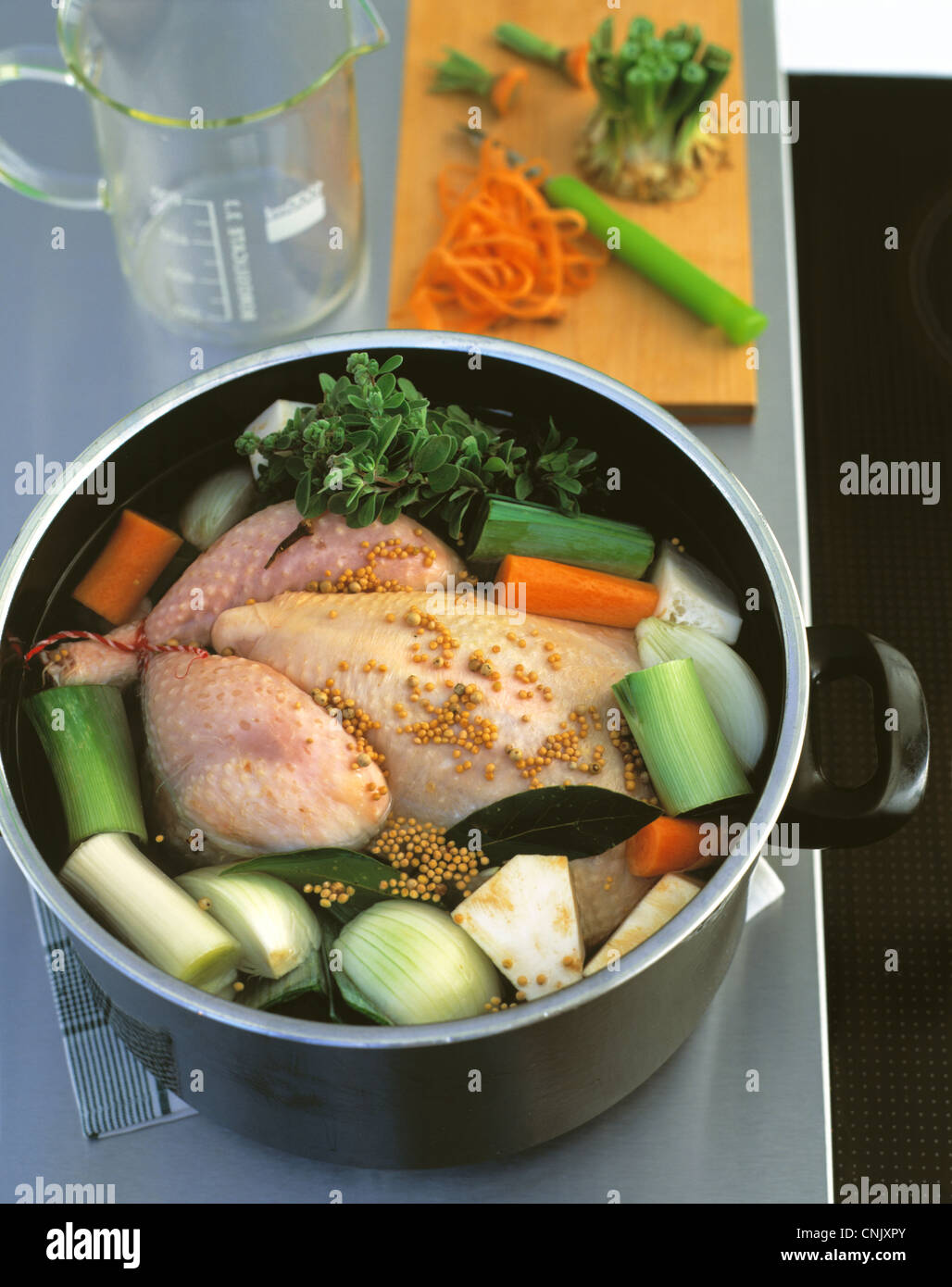 Laying chicken and all ingredients into a pot Stock Photo - Alamy