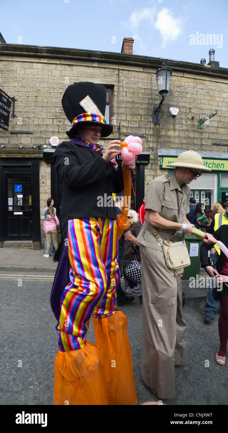 Man on stilts making balloon puppets Stock Photo - Alamy