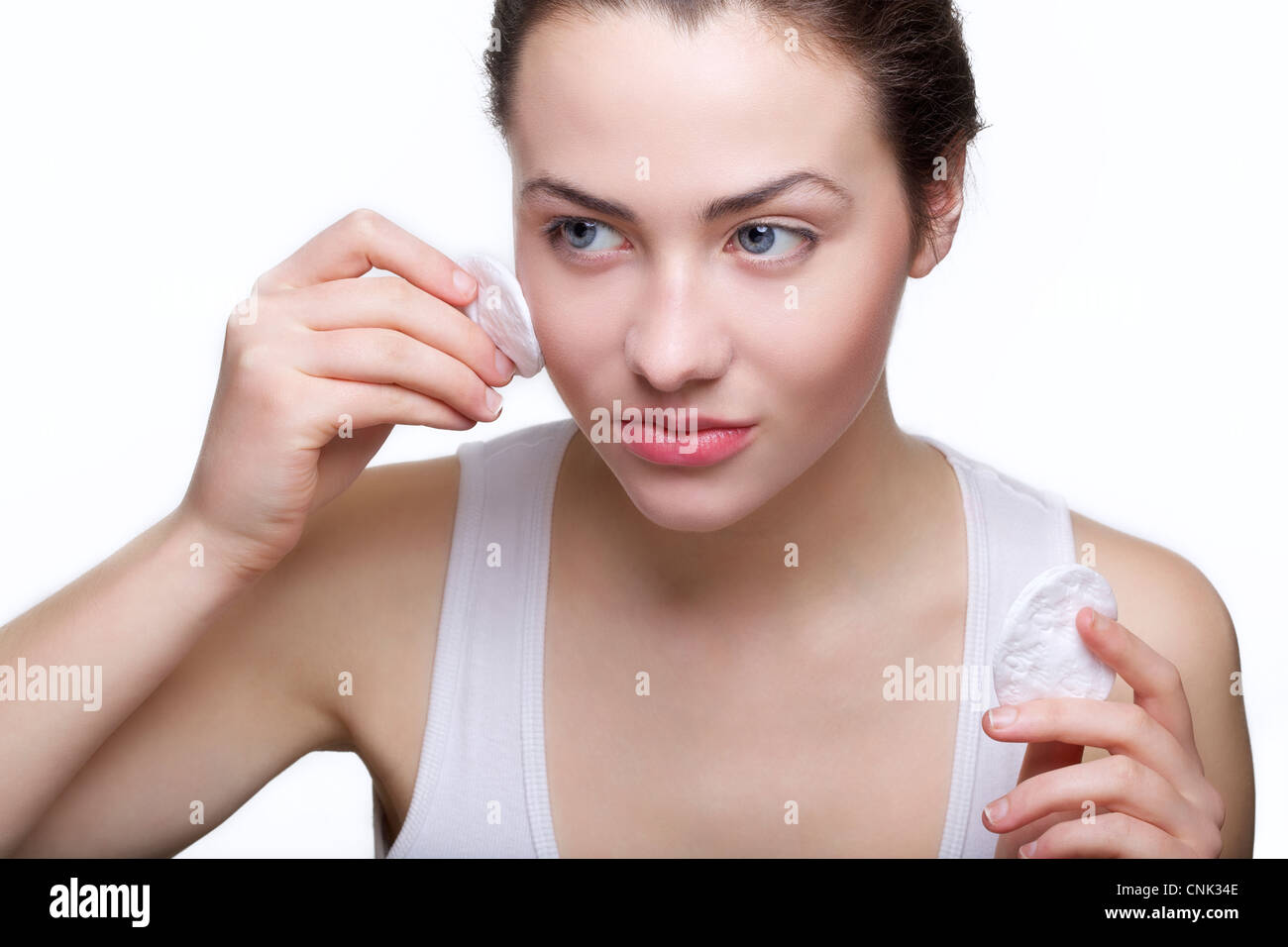Beautiful young woman cleaning her face with cotton facial pads Stock ...